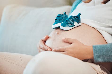 여성 미래의 어머니 또는 어린이 어린이 또는 모성을 위한 소파에 임신 배꼽 및 아기 신발 여성 임신 또는 어린이용 운동화 꿈