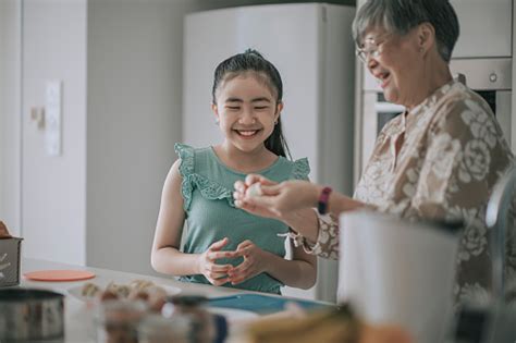 아시아 중국 노인 표시 하 고 가르치는 그녀의 손녀 준비 중국 만두 에 부엌 에 주말 여가 시간 요리하기 음식 준비에 대한 스톡