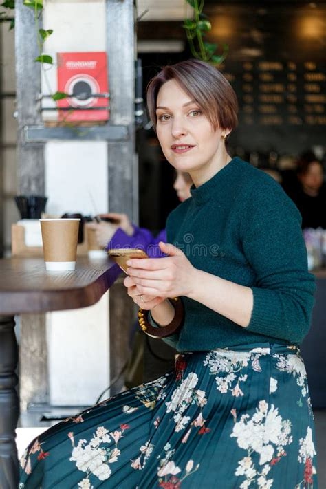 Beautiful Cute Girl In The Cafe Near The Window With Coffee Smiling