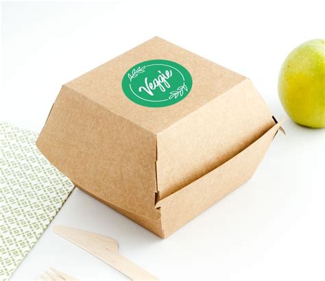 An Apple And Wooden Utensils On A White Surface Next To A Cardboard Box
