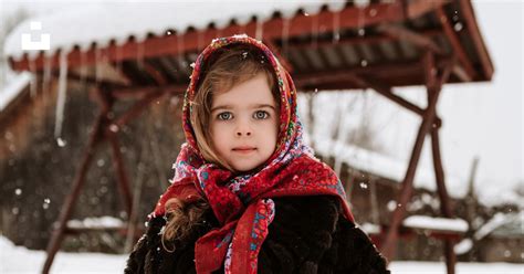 코트와 스카프를 입고 눈 속에 서 있는 어린 소녀 사진 Unsplash의 무료 의류 이미지