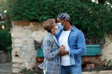 야외에서 키스 보호 얼굴 마스크를 착용 하는 연인의 커플 도시 거리에 얼굴 마스크 키스로 덮여 남자 친구와 여자 친구와 새로운 정상적인 관계 개념 코비드 검역에 대한 사랑