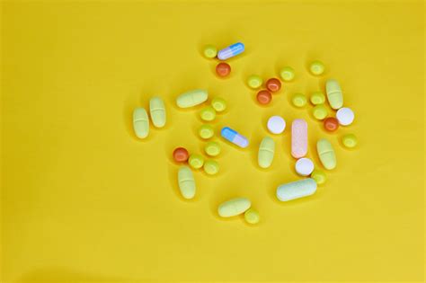 노란색 배경에 제약 다채로운 알 약과 캡슐 표면에 정제의 큰 숫자 현대 치료 약국 의료의 개념 0명에 대한 스톡 사진 및 기타