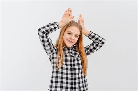 흰색 배경 위에 서서 토끼 귀 제스처를 하는 재미있는 십 대 소녀는 손바닥이 행복하고 기뻐 보인다 부활절 토끼 개념입니다 행복한
