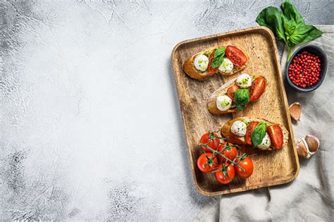 브루슈타와 토마토 모짜렐라 치즈 바질 이탈리아 어피타이저 또는 스낵 안티파소 회색 배경 맨 위 보기입니다 복사 공간 0명에 대한