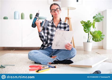 Woman Who Is Assembling Furniture In Her Home As Part Of A Renovation