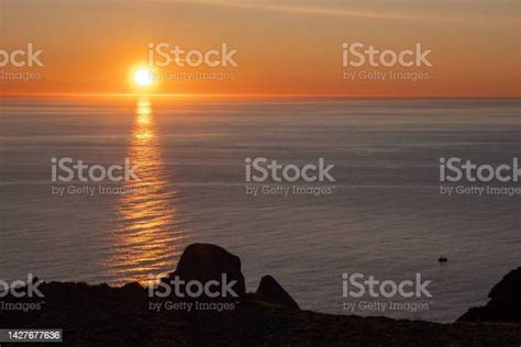 노르웨이의 멋진 풍경 노르드노르게 Nordkapp 에서 한밤중의 태양 일몰의 아름다운 풍경 절벽에있는 보트와 지구본 물결 모양의