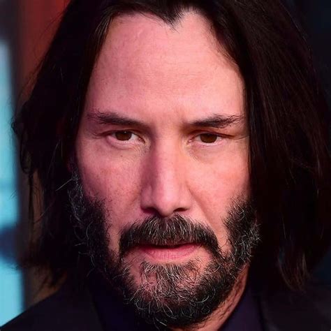 Download Keanu Reeves Posing With Confidence In A Black Suit And Tie Wallpapers Com