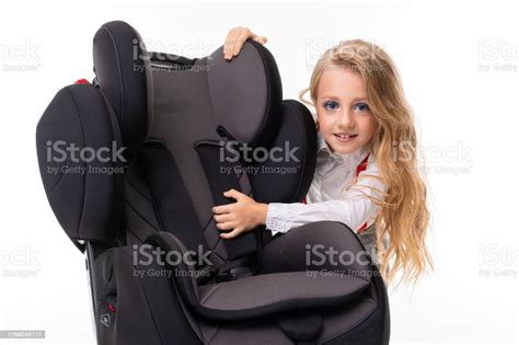 흰색 셔츠 빨간 풀업 케이지의 바지 빨간 양말과 아기 의자가있는 신발에 메이크업과 금발 머리를 가진 어린 소녀 귀여운에 대한