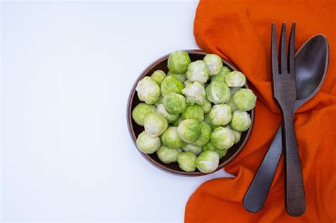 나무 포크와 숟가락은 테이블에 누워 잘 익은 브뤼셀 콩나물 옆에 나무 그릇에 거짓말 흰색 배경에 0명에 대한 스톡 사진 및 기타 이미지 Istock