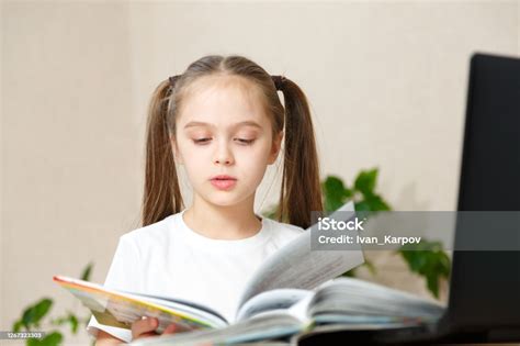 흰색 티셔츠를 입은 어린 소녀가 숙제를 합니다 일광 독립 소녀 교육이 있는 밝은 방 T 셔츠에 대한 스톡 사진 및 기타 이미지