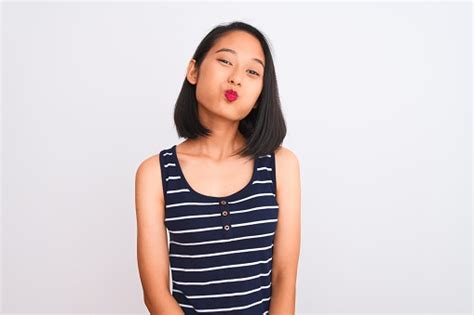 젊은 중국 여자 스트라이프 티셔츠 를 입고 고립 된 흰색 배경 퍼핑 뺨 에 서 재미있는 얼굴 공기 미친 표정으로 입이 팽창 T 셔츠에 대한 스톡 사진 및 기타 이미지