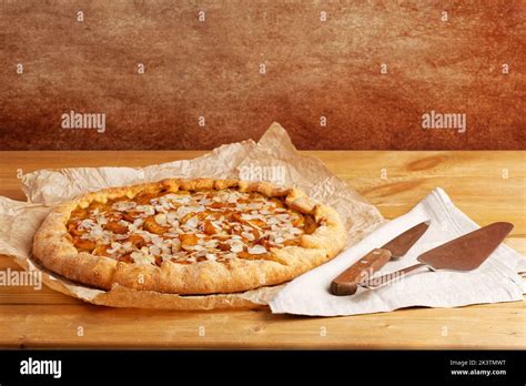 Homemade Pie With Plums And Almond Petals On Parchment Paper Copyspace