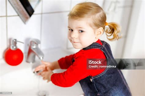 귀여운 작은 유아 소녀는 화장실에서 비누와 물로 손을 씻는다 사랑스러운 아이 학습 청소 신체 부위 아침 위생 루틴 집이나 보육원에서 행복한 건강한 아이 2 3 살에 대한
