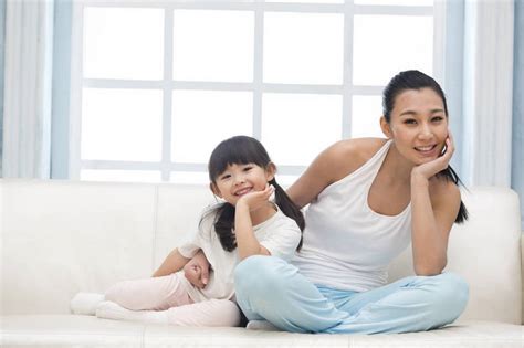 东方人儿童成年人两个人家庭父母母亲女儿客厅坐盘腿微笑横图彩色照片室内白天快乐幸福纯洁美景窗户北京