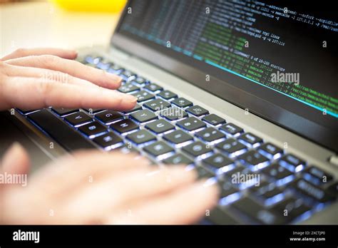 a person s hands are typing on a laptop displaying hacker code