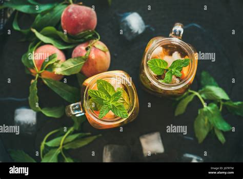 Summer Refreshing Cold Peach Ice Tea With Fresh Mint In Glass Jars On
