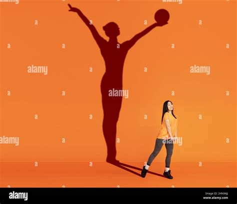 Young Pretty Girl Dreams Of Becoming Gymnast Isolated On Orange