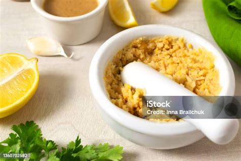 삶은 병아리콩과 마늘을 레몬 주스와 세라믹 박격포에 철저히 섞습니다 허머스를 만들기 위한 재료 삶은 병아리콩 타히니 마늘 레몬 버터 단계적으로 0명에 대한 스톡 사진 및