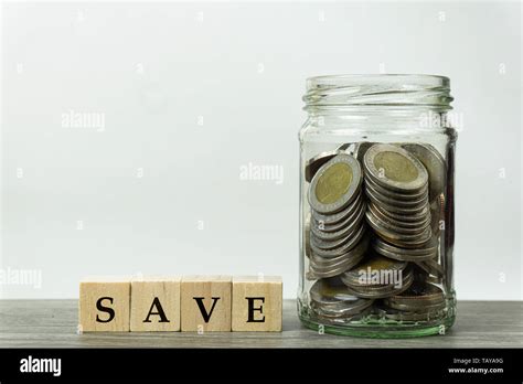 Saving Money Concepts Stacked Coins In Glass Jar And Wooden Block On