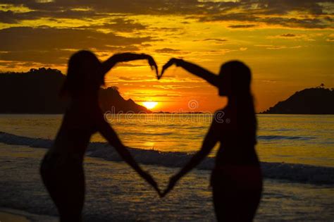 Silhouet Van Twee Meisjes Bij Zonsondergang Stock Foto Image Of