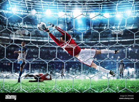 Goalkeeper Catches The Ball In The Stadium During A Football Game Stock