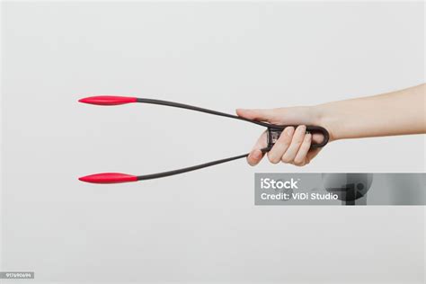 여성 손 들고 검은색과 빨간색 부엌 Salat 집게 흰색 배경에 고립의 플라스틱 쌍 봉사 수평 닫습니다 주방 기구 개념입니다 광고에 대 한 공간을 복사 합니다 0명에 대한