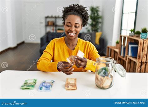 African American Woman Sitting On Table Pulling Apart Rand Banknotes At Home Stock Image Image