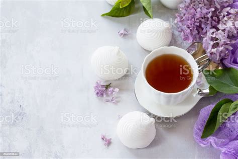 흰색 섬세 한 접시에 섬세 한 바닐라 마 시 멜로입니다 마쉬 멜 로우 한 잔의 차와 라일락 라일락 빈티지 돌 배경으로 여전히