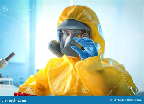 Scientist In Chemical Protective Suit With Microscope Slide Virus