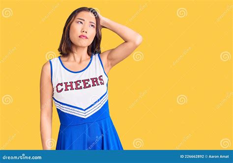 Young Beautiful Chinese Girl Wearing Cheerleader Uniform Confuse And
