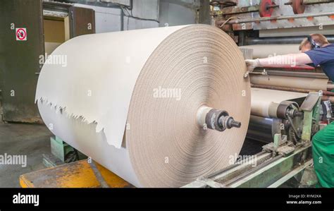A Huge Roll Of Paper Sheets Being Loaded In Rapina Estonia Going Into The Machine Being Held By