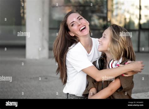 Mother Hugs With Daughter Schoolgirl Outdoors Cheerful Teen And Female