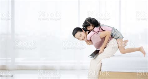 좋은 여자와 그녀의 어머니는 함께 즐길 수 있습니다 집에서 즐거운 시간을 보내고 있습니다 아이는 잠에서 깨어난다 아시아 가족