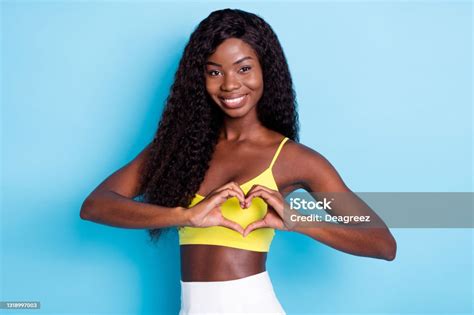 밝은 파란색 배경에 고립 된 심장 모양을 보여주는 매력적인 쾌활한 물결 모양의 여자 친구의 초상화 갈색 머리에 대한 스톡 사진