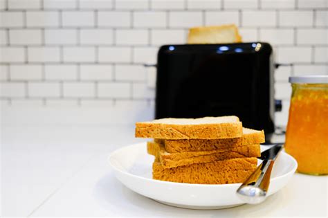 집에서 건강 한 아침 식사를 위한 오렌지 잼 병이 있는 토스터에 통 밀 빵 흰색 벽돌 벽 배경 0명에 대한 스톡 사진 및 기타