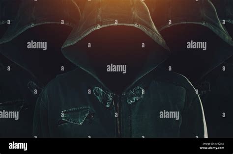 Group Of Hooded Computer Hackers With Obscured Faces Lined Up In