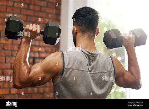 Push Yourself Until Youre Proud A Young Man Working Out With Dumbbells