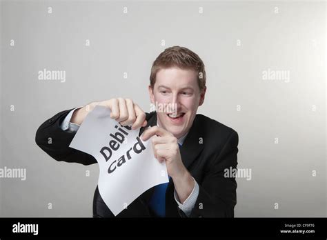 Man In A Suit Sat At A Desk Ripping A Piece Of Paper Up With The Words