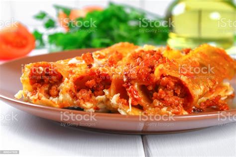 전통 이탈리아 파스타 Cannelloni입니다 구운된 관 파 르 마 치즈와 흰색 나무 테이블에 볘 샤 멜 소스와 다진된 고기와