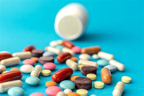 一握りの色の丸薬が青い背景に缶からこぼれ落ちた医療コンセプト ウクライナのストックフォトや画像を多数ご用意 ウクライナ カットアウト