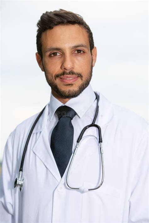 Hübscher Doktor Im Weißen Mantel Mit Stethoskop Stockfoto Bild Von