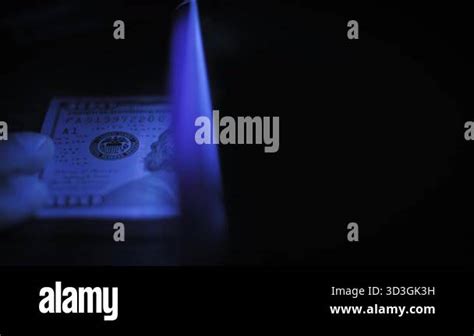 Macro Shot Checking A One Hundred Dollar Bill For Authenticity Using An