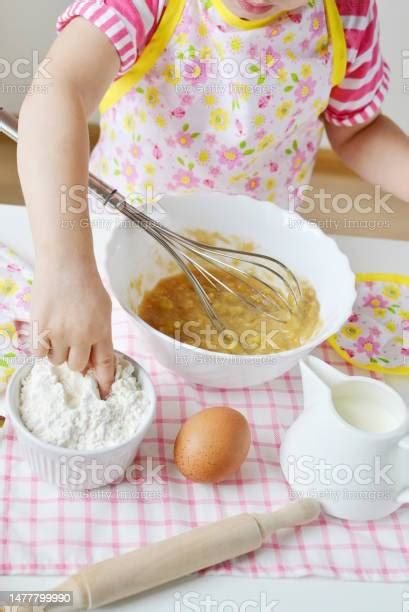 부엌에서 요리하는 작은 백인 소녀 가정 조기 교육 개발 앞치마 재료 반죽 바나나 팬케이크 준비 2 3 살에 대한 스톡 사진 및