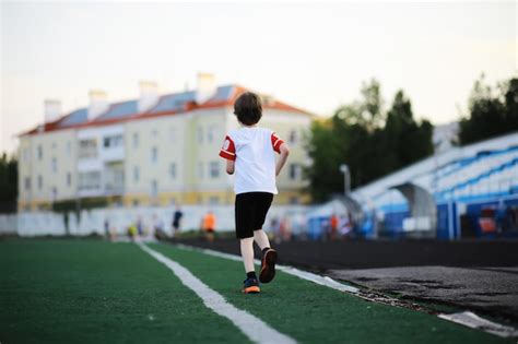 A Criança Pratica Esportes No Estádio O Menino Está Treinando Antes De