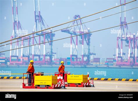 Chinese Workers Labor At The Fully Automated Container Terminal At The Port Of Qingdao In