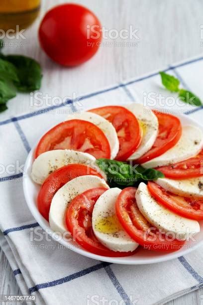모짜렐라 토마토 바질을 곁들인 수제 카프레제 샐러드를 흰색 접시에 담아 측면 보기 냅킨에 대한 스톡 사진 및 기타 이미지