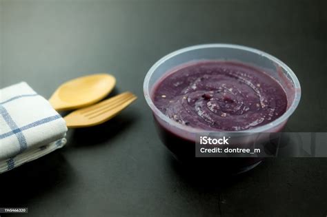 맛 있는 수 제 퓌 레 보라색 감자 크림 수프 부엌 천과 나무 포크와 숟가락 옆에 검정색 배경에 넣습니다 그릇에 대한 스톡 사진