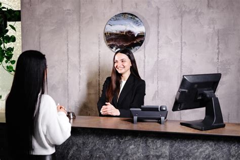Premium Photo Friendly Young Concierge Standing Behind A Reception