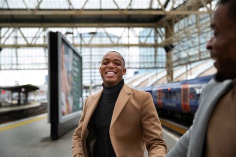 Free Photo Gay Couple Holding Hands At The Train Station While On A Date